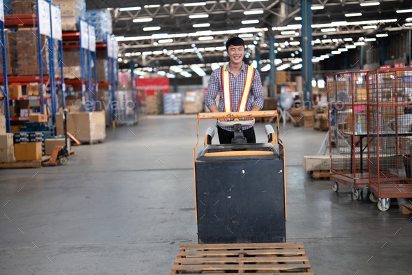 Warehouse worker pulling manual hand pallet lift Stock Photo by ...