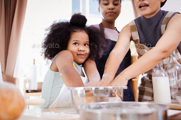 African American family help prepare the flour for making cookies ...