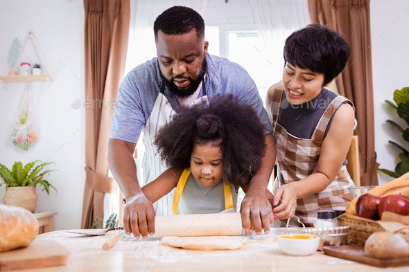 African American family help prepare the flour for making cookies ...