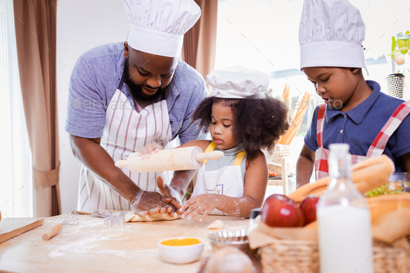 African American family help prepare the flour for making cookies ...