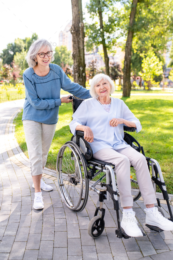 Senior female best friends with disability walking at the park Stock ...
