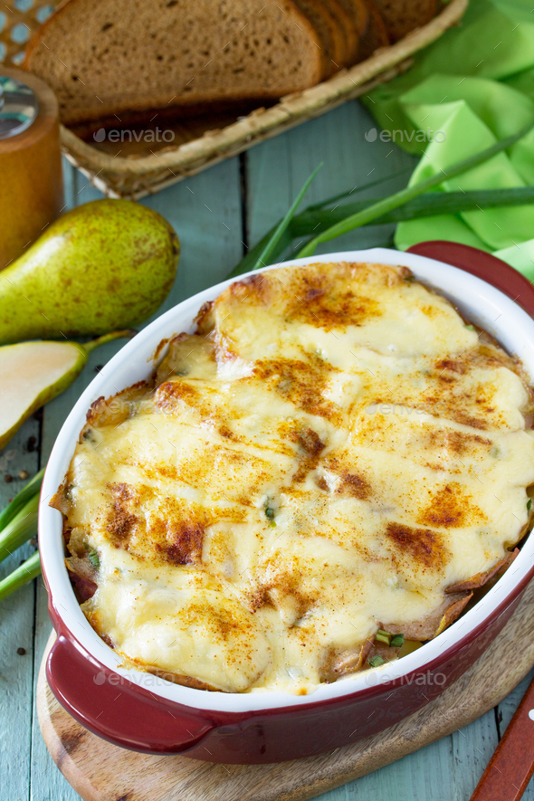 Potato gratin with pear, raclette cheese, and bacon. Stock Photo by ...