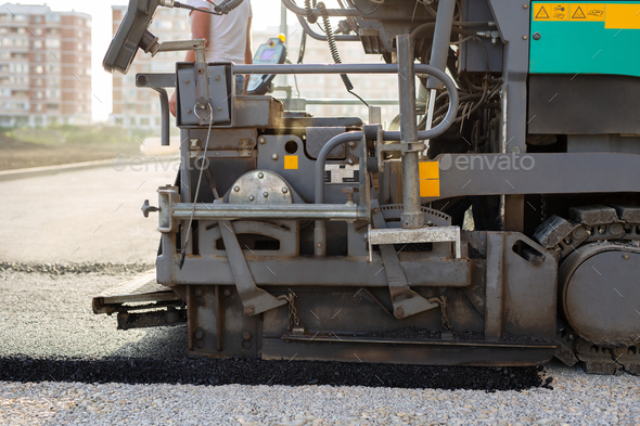 An asphalt spreader or an asphalt paver machine on a road construction ...