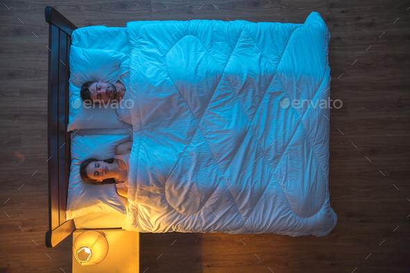 The couple sleeping on the bed. evening night time. view from above ...