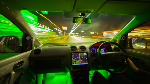The man drive a car in the night city. Wide angle. Left side traffic ...