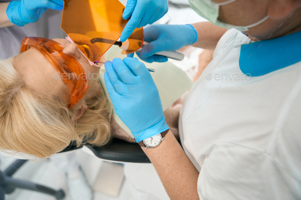 Charming Caucasian woman is getting teeth treatment in stomatology ...