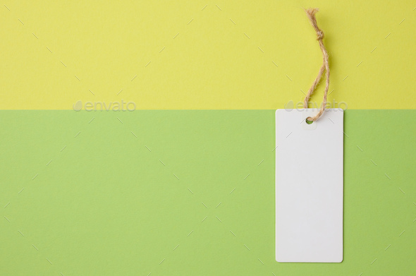 Empty white cardboard tag on brown rope, green background Stock Photo ...