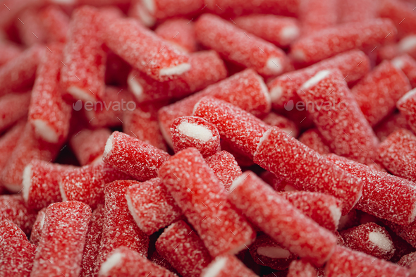 Red gummies jelly candies in sugar, background. Stock Photo by puhimec