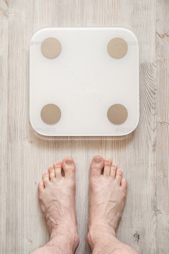 bare feet stand next to smart scales makes bioelectric impedance ...