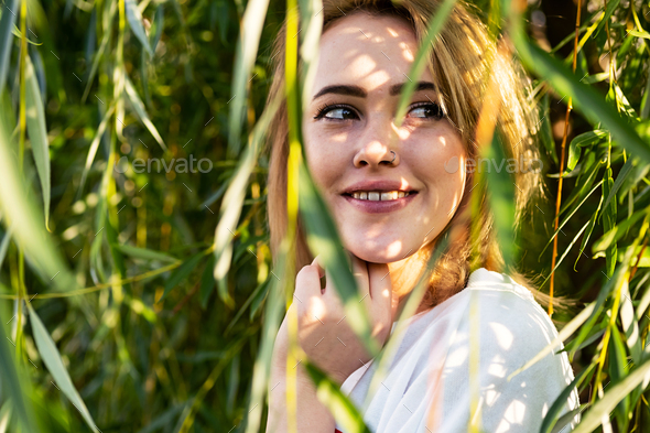 Woman Smiling under Willow Tree in Sunlight with Shadow from Branches ...
