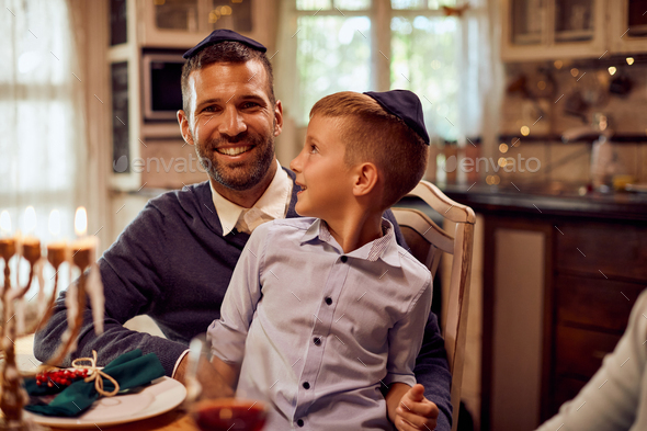 Happy Jewish father and son enjoying in Hanukkah celebrating in dining ...