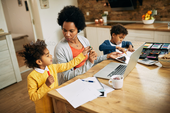 African American single mother with two kids working at home. Stock ...