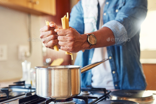 I know how to make a good spaghetti. Shot of a man breaking spaghetti ...