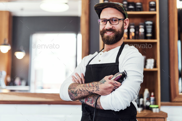 Portrait of a handsome young barber posing with his arms folded inside ...