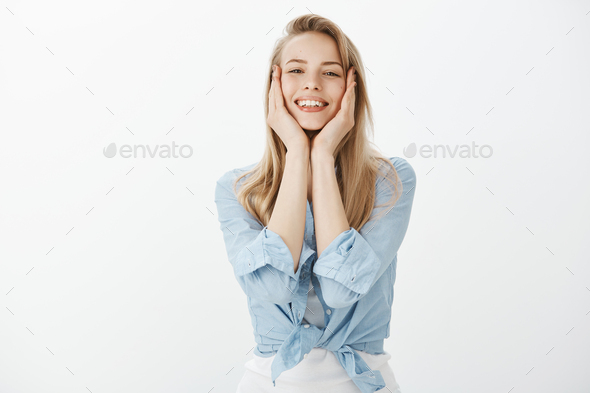 Good-looking cute female student in stylish outfit, touching face with ...