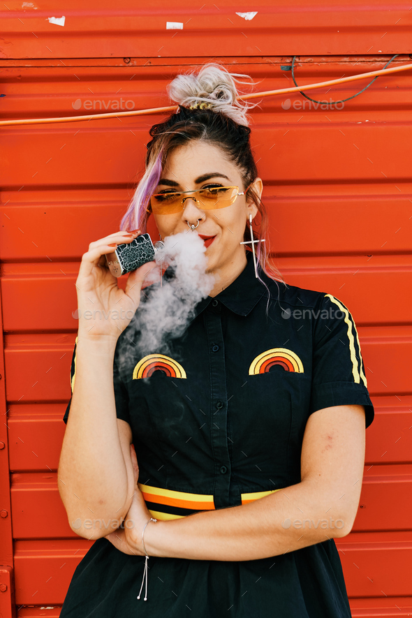 young girl with alternative look using vaporizer - lifestyle concept ...