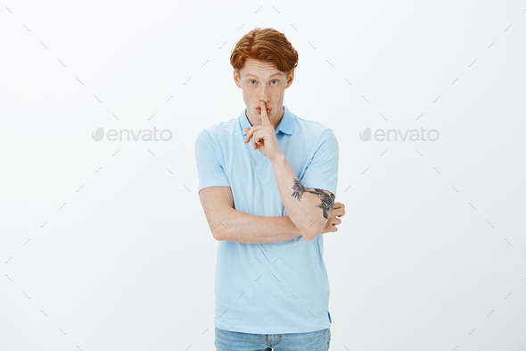 Let us keep it our secret. Charming redhead male model in casual ...