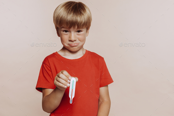 Cute little boy with thermometer toy does sad sick face Stock Photo by ...