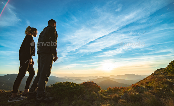The couple standing on the beautiful mountain sunset background Stock Photo by artemp3