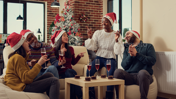 Festive people clinking wine glasses and celebrating christmas event ...