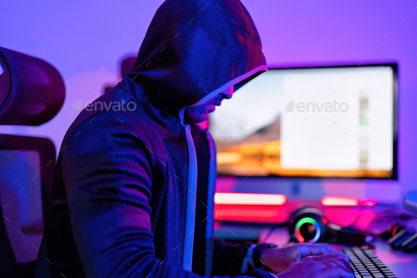 hacker wearing hood jacket typing computer keyboard to phishing steal ...