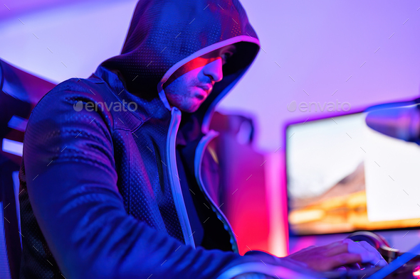 hacker wearing hood jacket typing computer keyboard to phishing steal ...