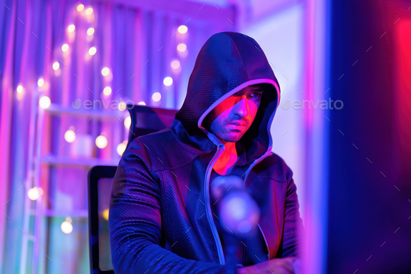 hacker wearing hood jacket typing computer keyboard to phishing steal ...