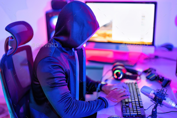 hacker wearing hood jacket typing computer keyboard to phishing steal ...