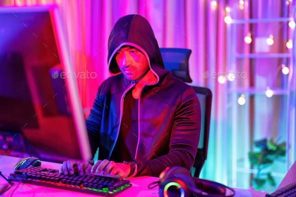 hacker wearing hood jacket typing computer keyboard to phishing steal ...