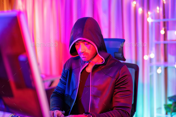 hacker wearing hood jacket typing computer keyboard to phishing steal ...