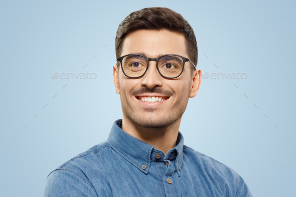 Portrait of handsome guy wearing glasses, looking aside thinking of ...