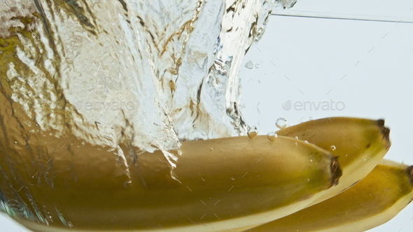 Organic bananas falling water closeup. Delicious tropical fruits ...
