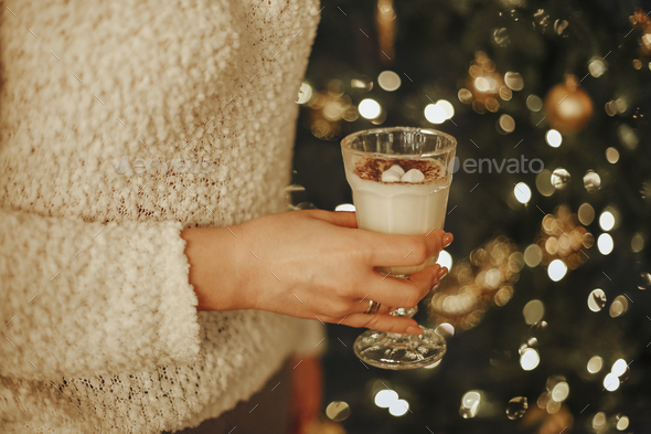 Woman drinking homemade eggnog decorated with marshmallows while ...