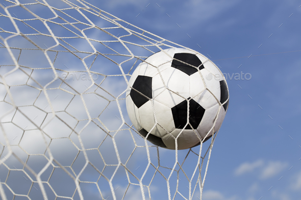 soccer ball in the net on blue sky background Stock Photo by FamilyStock