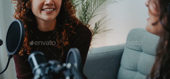 Latin host recording radio podcast interview with guest at home office ...