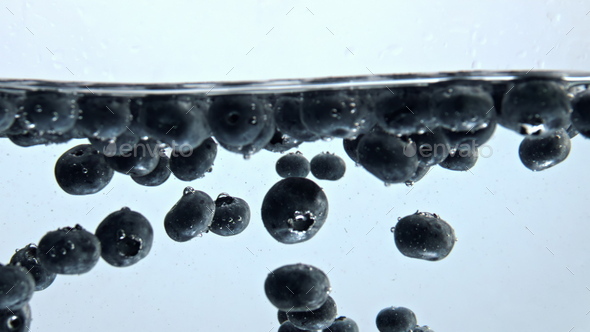 Blueberry inside transparent aqua vessel closeup. Water with berries in ...