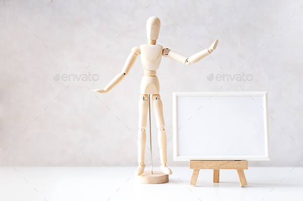Empty picture frame mock up in minimalist interior with wooden puppet ...