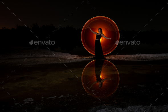 Woman posing for light painting with bright lights in the dark ...