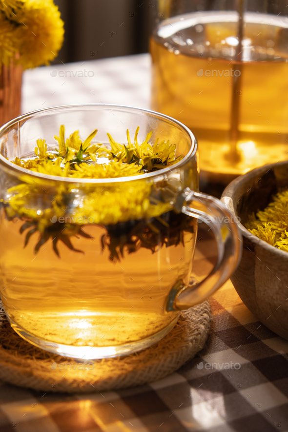 Dandelion flower healthy tea in glass teapot and glass cup on table ...