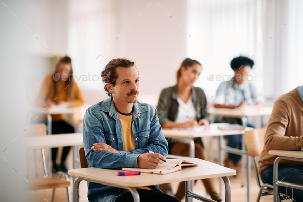 Mid adult student paying attention during lecture in the classroom ...