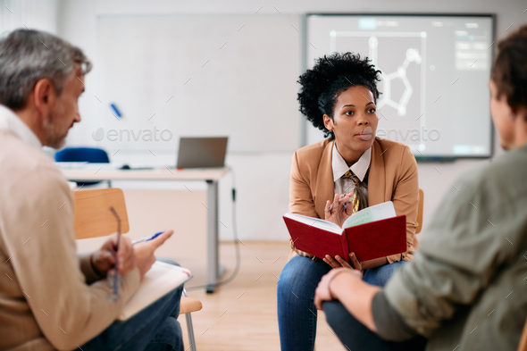 Black female professor having consultations with adult students at ...