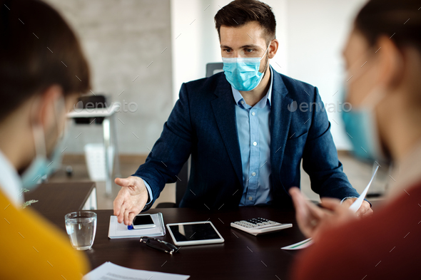 Insurance agent talking to clients while going through financial plans ...