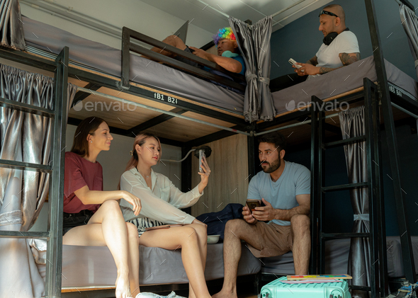 Groups of travelers of different nationalities having fun in the hostel ...