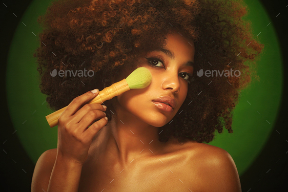 African woman applying powder and blush on her beautiful face, process ...