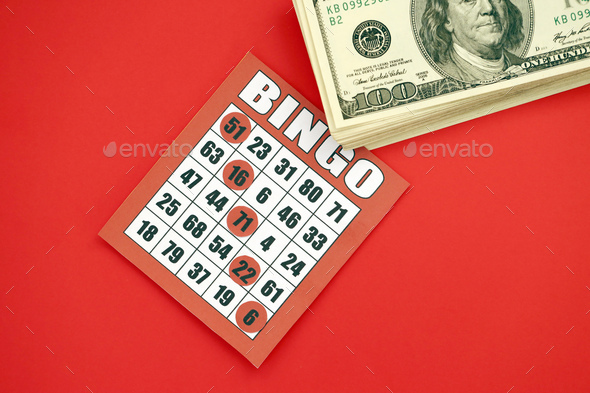 Red bingo board or playing card for winning chips and stack of dollar ...