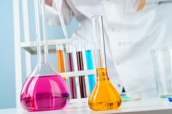 Colored liquids inside lab glassware on white table in laboratory Stock ...