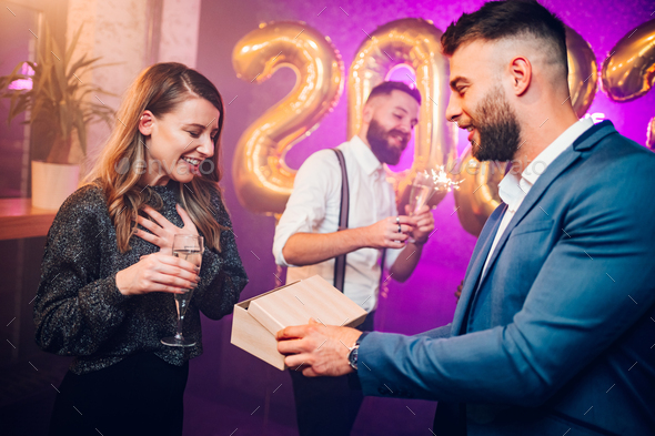 Couple exchanging gifts for birthday party or new years eve in the club ...