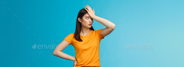 Annoyed arrogant asian girl punch forehead make facepalm sign, roll ...