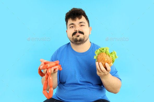 Concept of weight problems, young fat man on blue background Stock ...