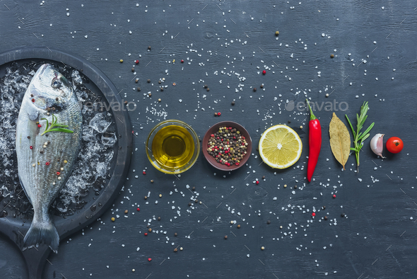 elevated view of arranged ingredients near tray with uncooked fish on ...